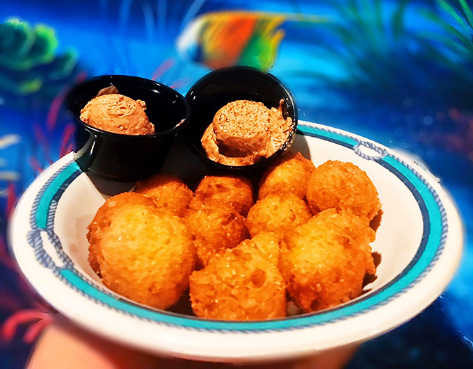 Golden-fried hush puppies that crunch like a satisfying secret, served with dipping sauces that make silence deliciously impossible.