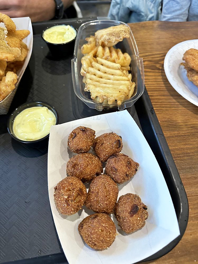 Hush puppies so perfectly golden they deserve their own trophy. These cornmeal spheres of joy are the unsung heroes of any seafood feast.