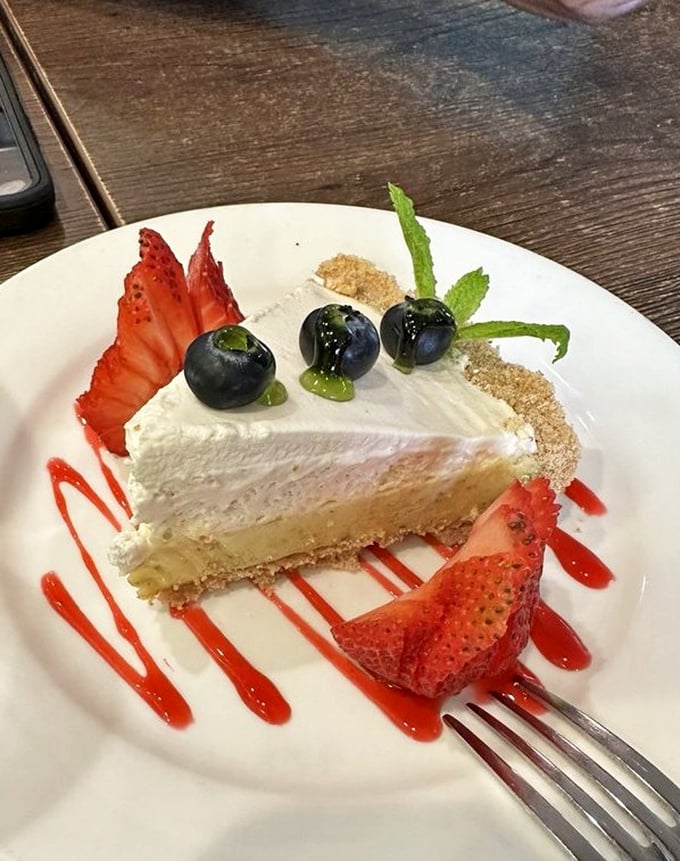 Key lime pie that strikes the perfect balance between sweet and tart, topped with blueberries that look like they're having a fancy party on a cloud.