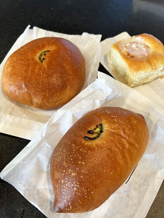 The holy trinity of kolache perfection: pillowy dough, savory fillings, and that telltale hint of jalape&ntilde;o peeking through like a green gem.