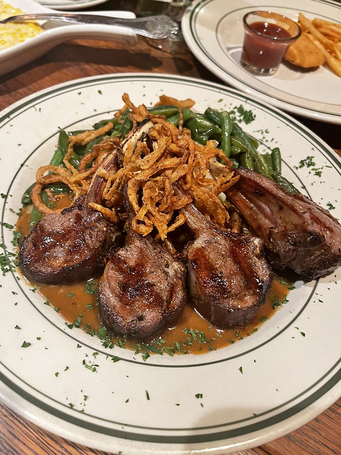 These lamb chops aren't just dinner; they're tiny meat lollipops for grown-ups, crowned with crispy onions and swimming in a sauce worth bottling.