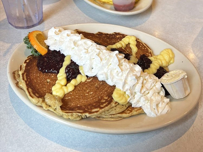 Pancakes that don't just sit on the plate&mdash;they perform. With whipped cream, fruit compote, and what appears to be artistic drizzles, this is breakfast as theater.