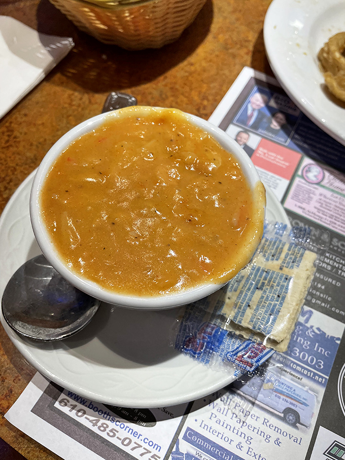 The lobster bisque arrives like liquid velvet in a bowl, rich enough to make you consider proposing marriage to soup.