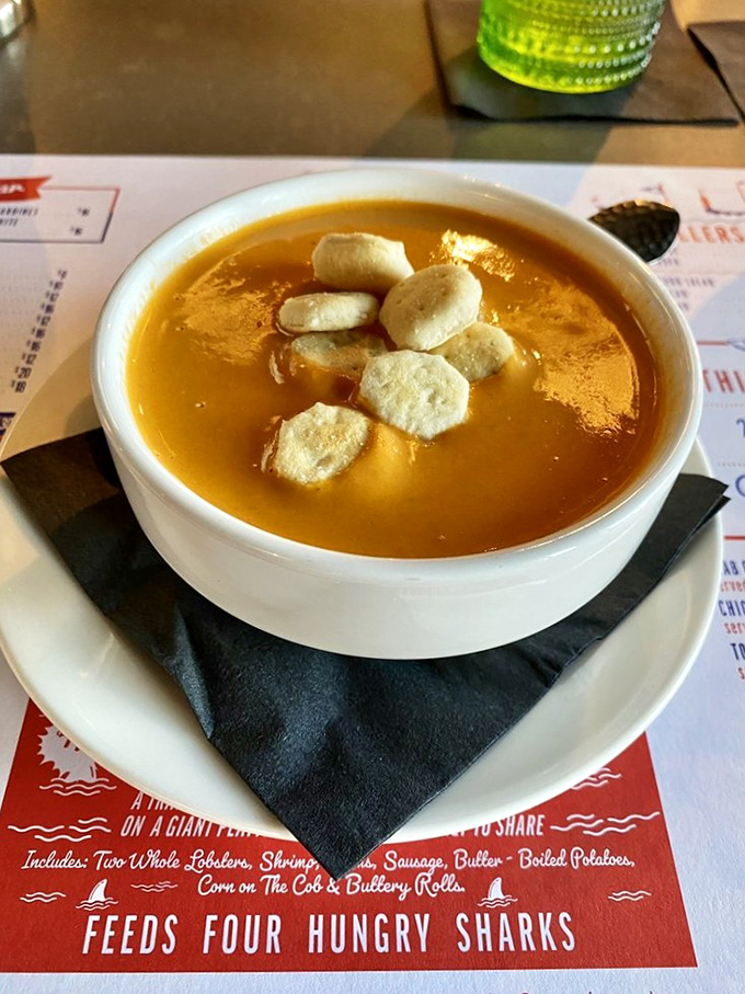 Lobster bisque that's practically liquid gold, topped with oyster crackers that bob like tiny lifeboats on a sea of creamy decadence.