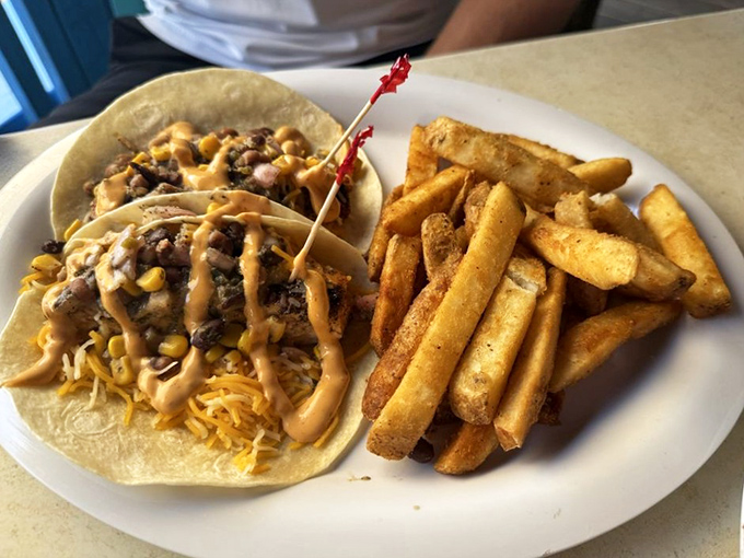 Tacos that tell a story of land meeting sea. The sauce drizzled across the top is like the final brushstroke on a culinary masterpiece.