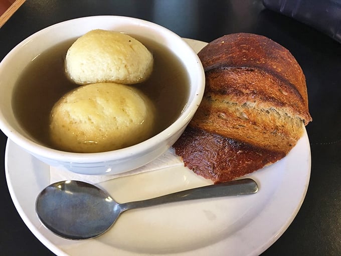 Two golden matzo balls floating like edible islands in a sea of comforting broth. Jewish penicillin at its most delicious.