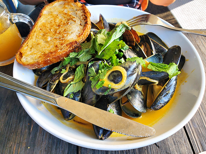 Mussels bathing in golden broth with perfectly grilled bread standing by&mdash;nature's most perfect sponge for the liquid gold left behind.