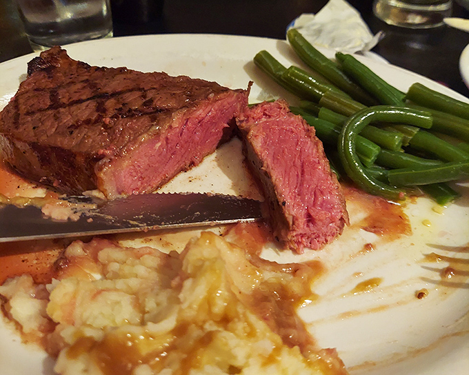 The New York Strip, sliced to reveal that perfect pink center&mdash;proof that simplicity, when executed flawlessly, needs no embellishment.