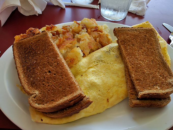 The breakfast trinity: perfectly folded omelet, golden-brown toast, and home fries that somehow manage to be both crispy and tender&mdash;a morning miracle.