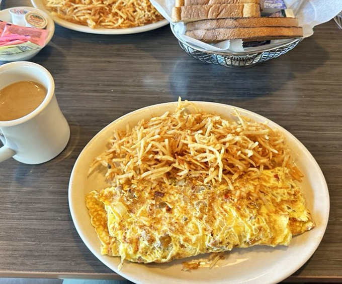 This cheese omelet wears its shredded cheese crown like royalty. The home fries alongside aren't just a side dish &ndash; they're co-stars in this breakfast drama.