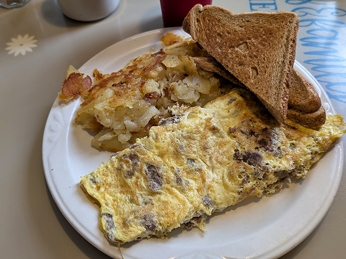 An omelette that knows its purpose in life&mdash;delivering melted goodness and hearty fillings with crispy home fries standing guard.