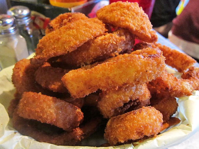 Golden-brown onion rings stacked like delicious Olympic rings. These aren't skinny afterthoughts—they're substantial enough to require a commitment.