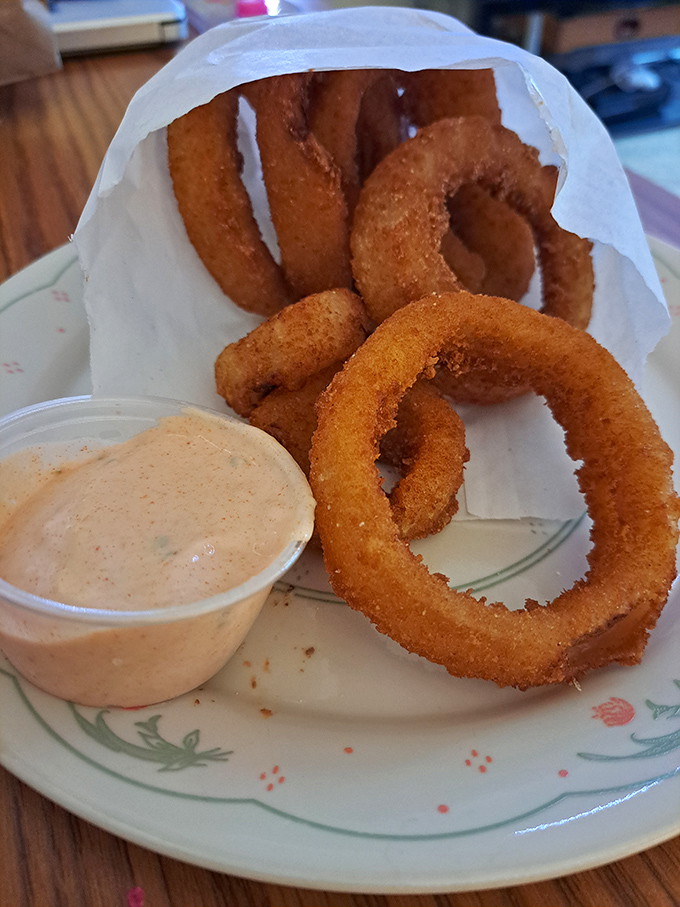 Golden, crispy onion rings that shatter with each bite, served with a dipping sauce that'll make you forget your table manners.