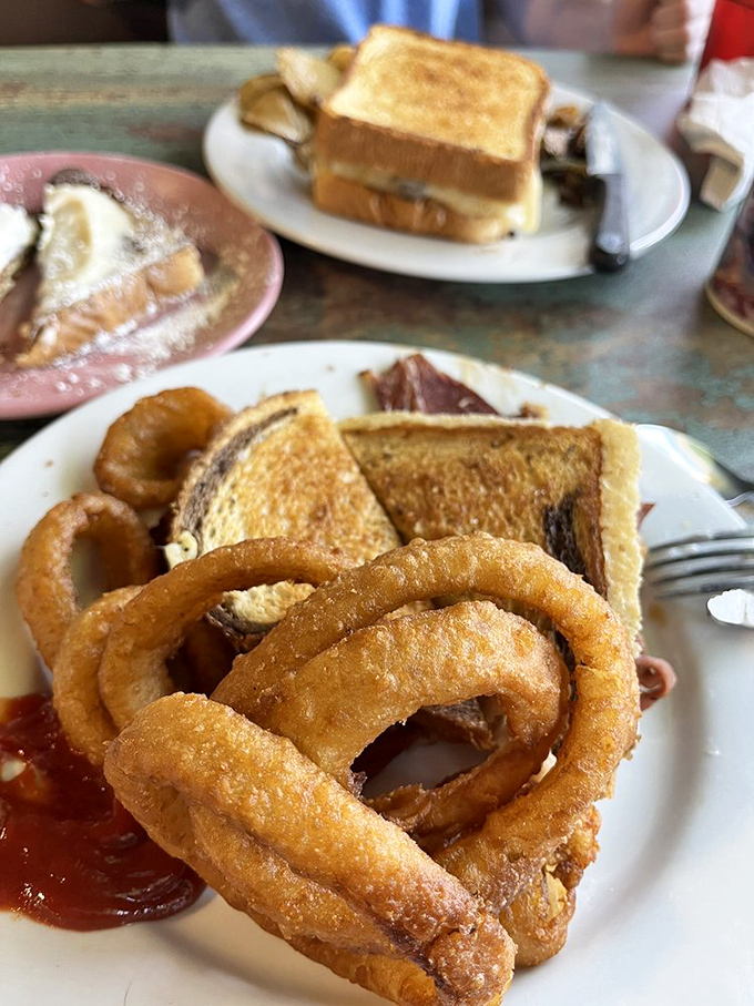 Golden onion rings that crunch loud enough to turn heads &ndash; paired with that perfectly toasted sandwich, it's lunch nirvana on a well-worn plate.