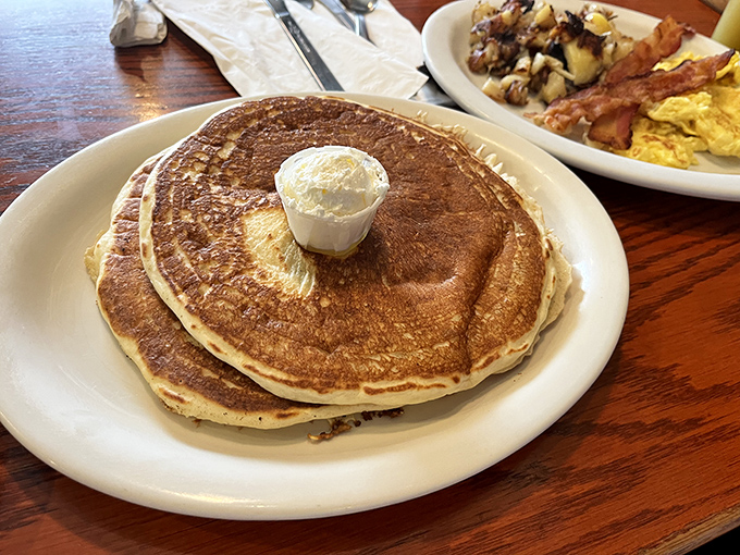 Golden-brown pancakes with a dollop of butter melting into their fluffy souls. Maple syrup application pending.
