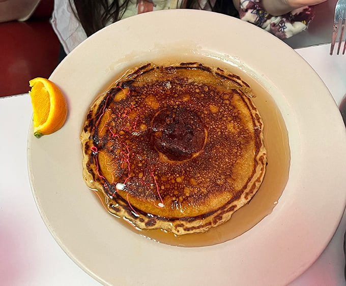This pancake isn't just breakfast&mdash;it's edible sunshine, glistening with maple syrup that pools in all the right places. Morning perfection on a plate.