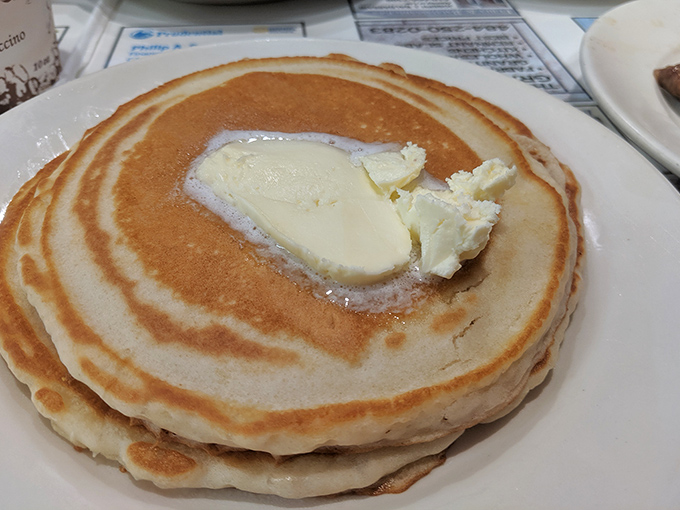 These pancakes aren't just breakfast, they're therapy—fluffy islands of comfort topped with melting butter that says "today will be okay."
