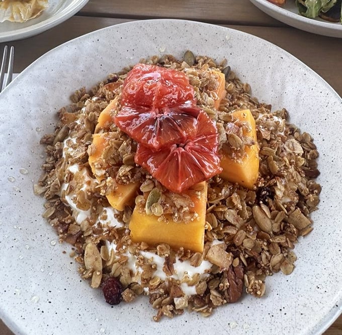 Breakfast of champions: mango chunks and citrus segments lounging on a bed of granola and yogurt. Whoever said healthy can't be heavenly never tried this.