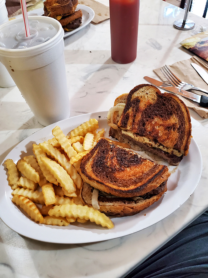 A patty melt that would make your cardiologist wince and your taste buds dance. Crispy, gooey, beefy perfection with those signature crinkle fries.