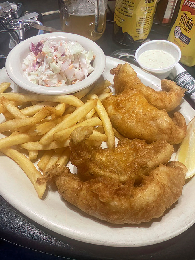 Golden-battered perch that shatters with each bite, paired with crispy fries and coleslaw that actually deserves to be eaten, not pushed aside.