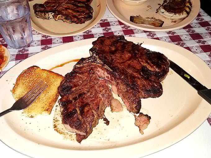 A porterhouse that demands respect and possibly its own zip code. The char speaks of open flames while that slice reveals the kitchen knows exactly what medium-rare means.