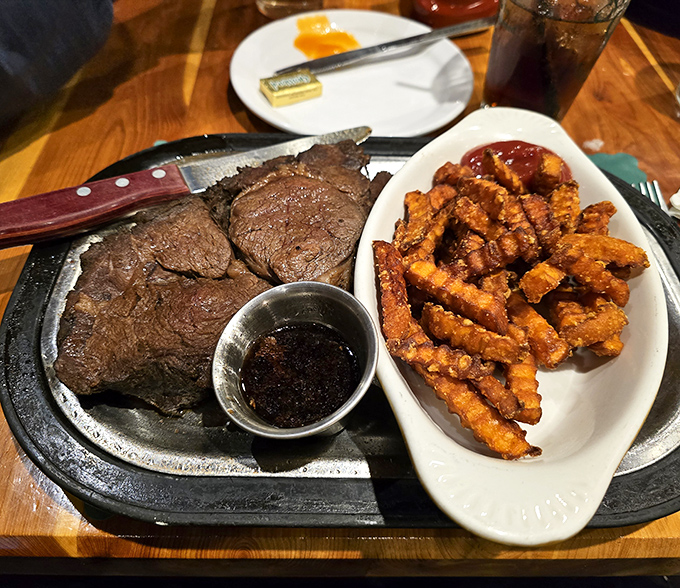 Sizzling prime rib on a hot plate with waffle fries&mdash;proof that sometimes the best things in life come on bright red plates.