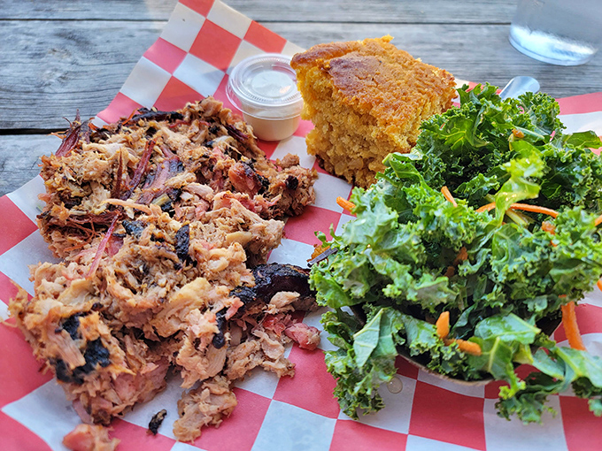 The barbecue trinity: tender pulled pork with bark bits, cornbread that would make grandma proud, and kale salad for when your conscience calls.