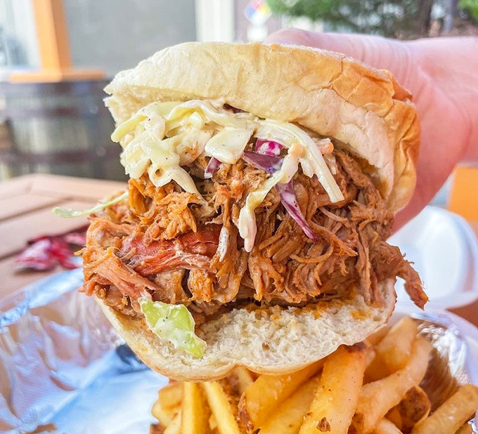 The pulled pork sandwich—where smoke meets sweet, where texture meets tang. That slaw isn't just a topping; it's the cool counterpoint to meat's warm embrace.