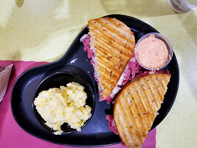 The Reuben arrives like a delicious architectural marvel—grilled to golden perfection with that telltale sauerkraut tang waiting to cut through the richness.
