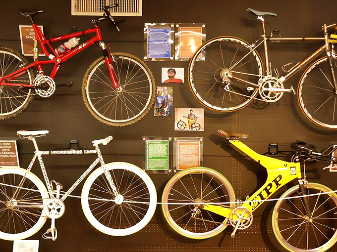 Racing bikes mounted like trophies showcase the evolution of speed. From "I think I can" to "catch me if you can" in just a few decades.