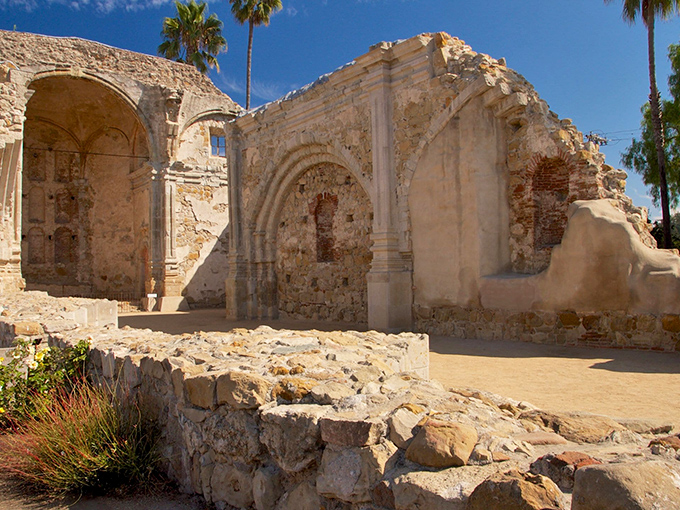 Sunlight plays architect through these crumbling arches, creating a cathedral of shadows more impressive than when the walls stood complete.