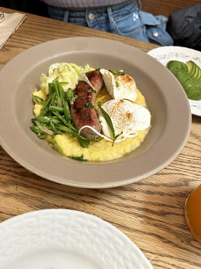 Creamy polenta cradles perfectly cooked sausage and eggs &ndash; comfort food that would make your Italian grandmother weep with joy.