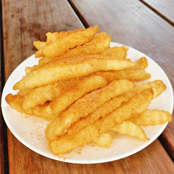 These aren't ordinary fries – they're seasoned accomplices to the main event, offering temporary refuge between bites of fiery chicken.