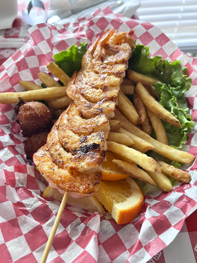 This shrimp skewer isn't just grilled&mdash;it's been given a PhD in flavor with a side of crispy fries and hushpuppies.