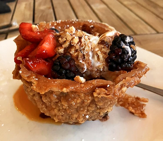Dessert architecture at its finest. This praline basket cradles fresh berries and cream like nature's most decadent bird nest.