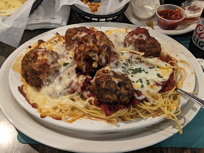 These aren't just meatballs; they're edible monuments to Italian-American cuisine, perched atop a mountain of spaghetti and blanketed in melted cheese.