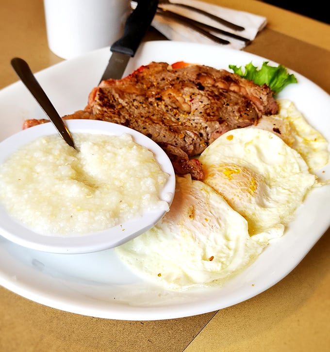 The holy trinity of breakfast: perfectly cooked steak, sunny-side-up eggs, and grits. A morning masterpiece that demands respect.