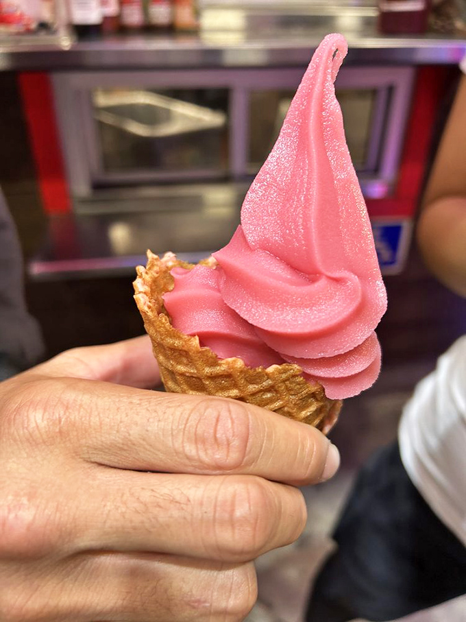 This pink swirl of strawberry dole whip could make even the grumpiest person smile – it's happiness in a waffle cone.