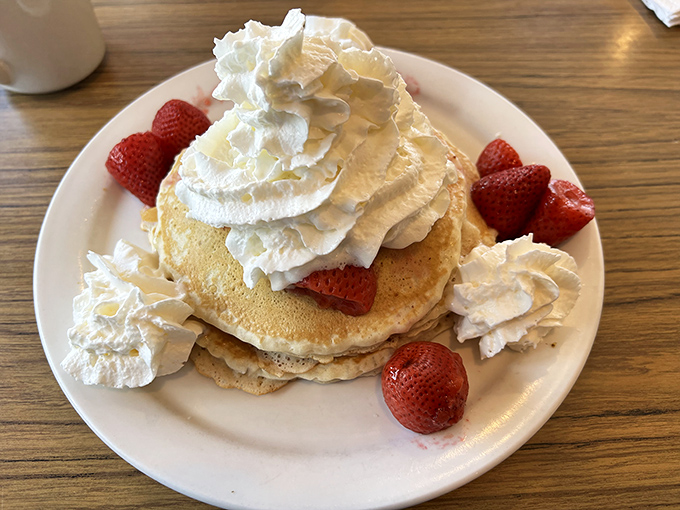 Pancakes that could make IHOP executives weep, crowned with fresh strawberries and whipped cream that doesn't come from a can. Breakfast royalty!