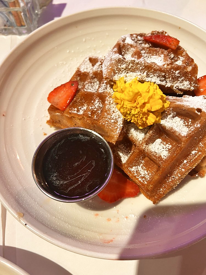 These waffles don't just sit there looking pretty—they arrive dusted with powdered sugar and ready for their close-up before disappearing bite by delicious bite.