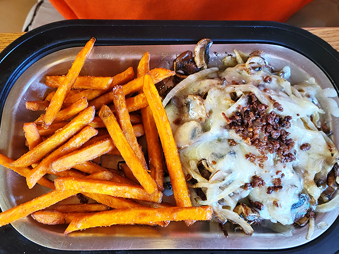 Sweet potato fries bringing their A-game alongside a mushroom and onion masterpiece that's wearing melted cheese like a well-deserved crown.