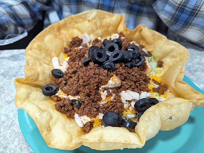 This taco salad isn't just wearing an edible bowl&mdash;it's sporting a party hat of seasoned beef, cheese, and olives that says "fiesta on a plate."