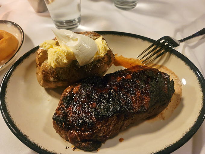 A masterpiece of simplicity: perfectly charred steak alongside a loaded baked potato that's practically begging to be devoured.