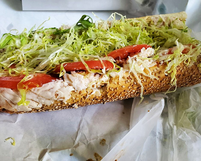Two golden-crusted hoagies stand at attention, their interiors revealing a harmonious marriage of meats, cheese, and just the right amount of veggies.