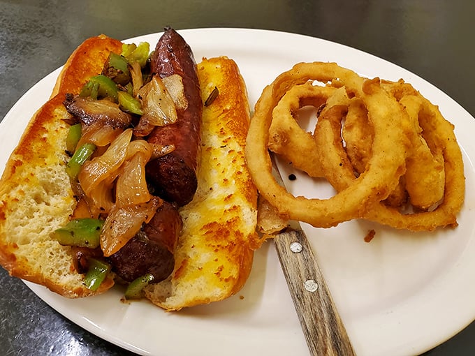 A hoagie that means business &ndash; smoky sausage nestled with caramelized onions and peppers, flanked by golden onion rings that could win beauty contests.