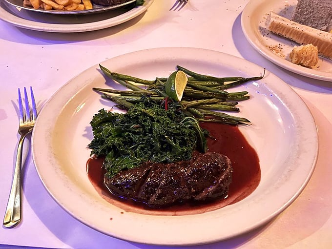 The venison tenderloin arrives like royalty in a pool of rich wine reduction. Paired with fresh greens and asparagus, it's wilderness sophistication on a plate.