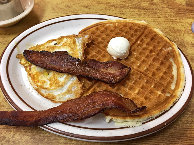 Breakfast diplomacy: a waffle, eggs, and bacon sharing a plate in perfect harmony. If only international relations could be this satisfying.