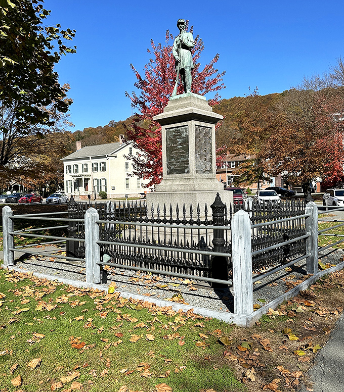 This dignified memorial stands as a quiet reminder of sacrifice, surrounded by autumn's vibrant tribute of crimson and gold.
