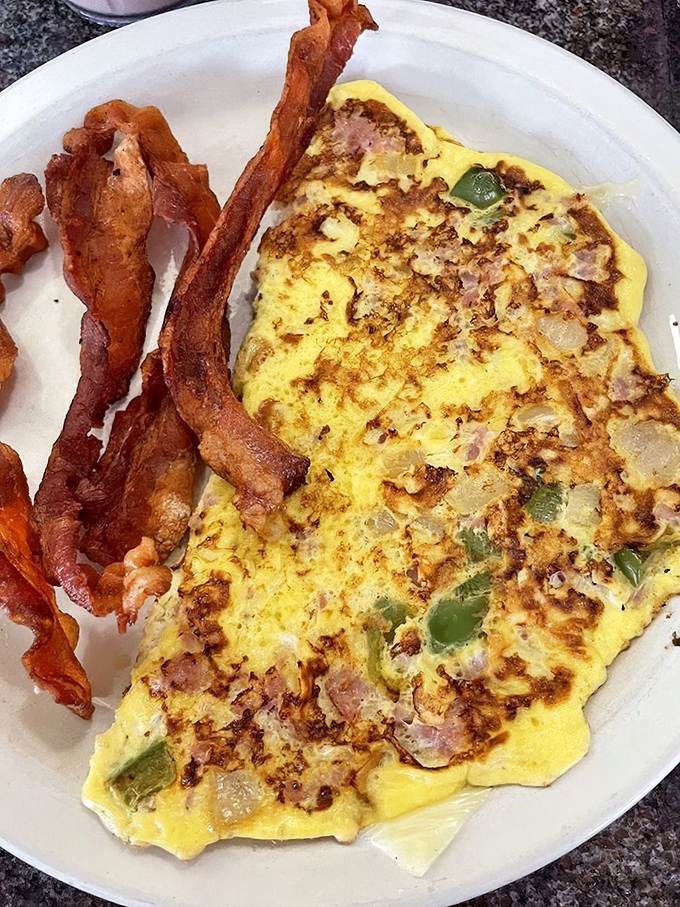 This Western omelet doesn't just contain vegetables – it celebrates them, nestled in fluffy eggs with those legendary home fries.