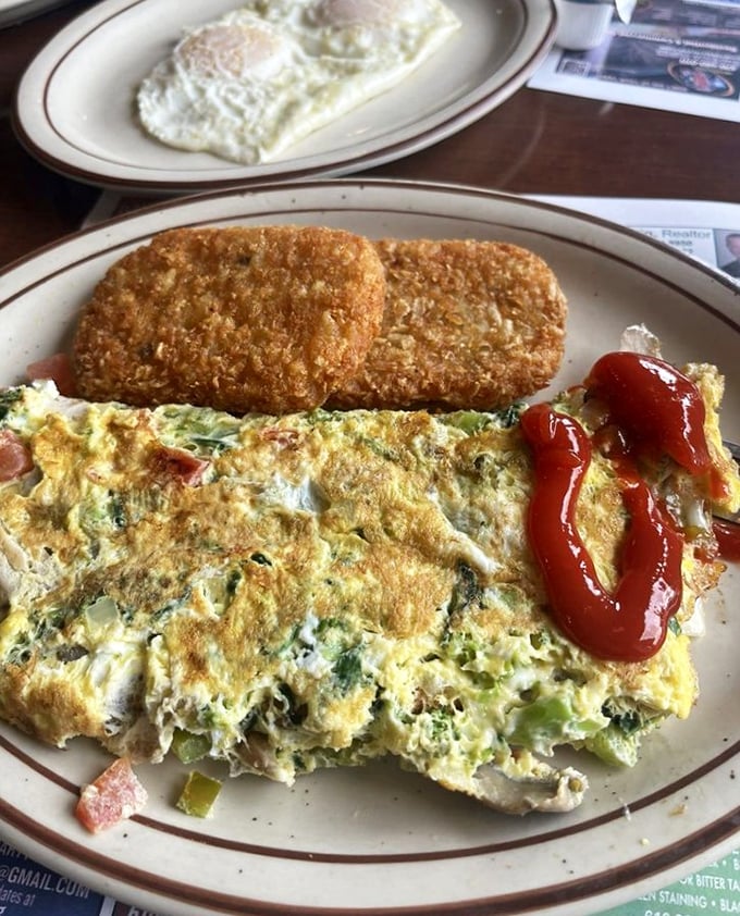 This isn't just an omelet; it's a masterclass in breakfast architecture – vegetables and cheese folded into eggs with mathematical precision.